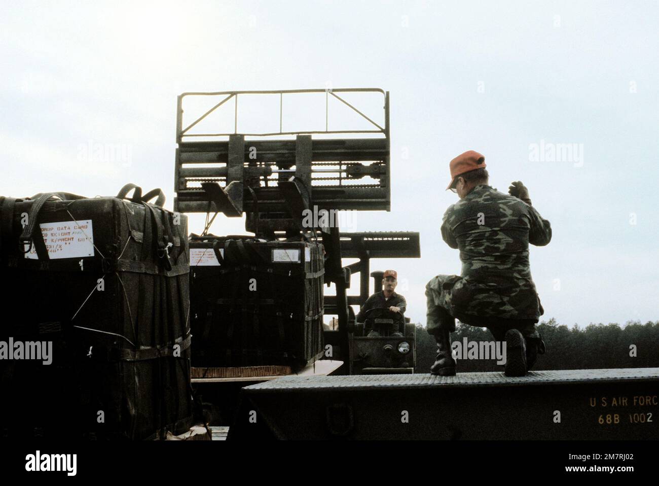 An airman directs a forklift operator to load a container delivery ...
