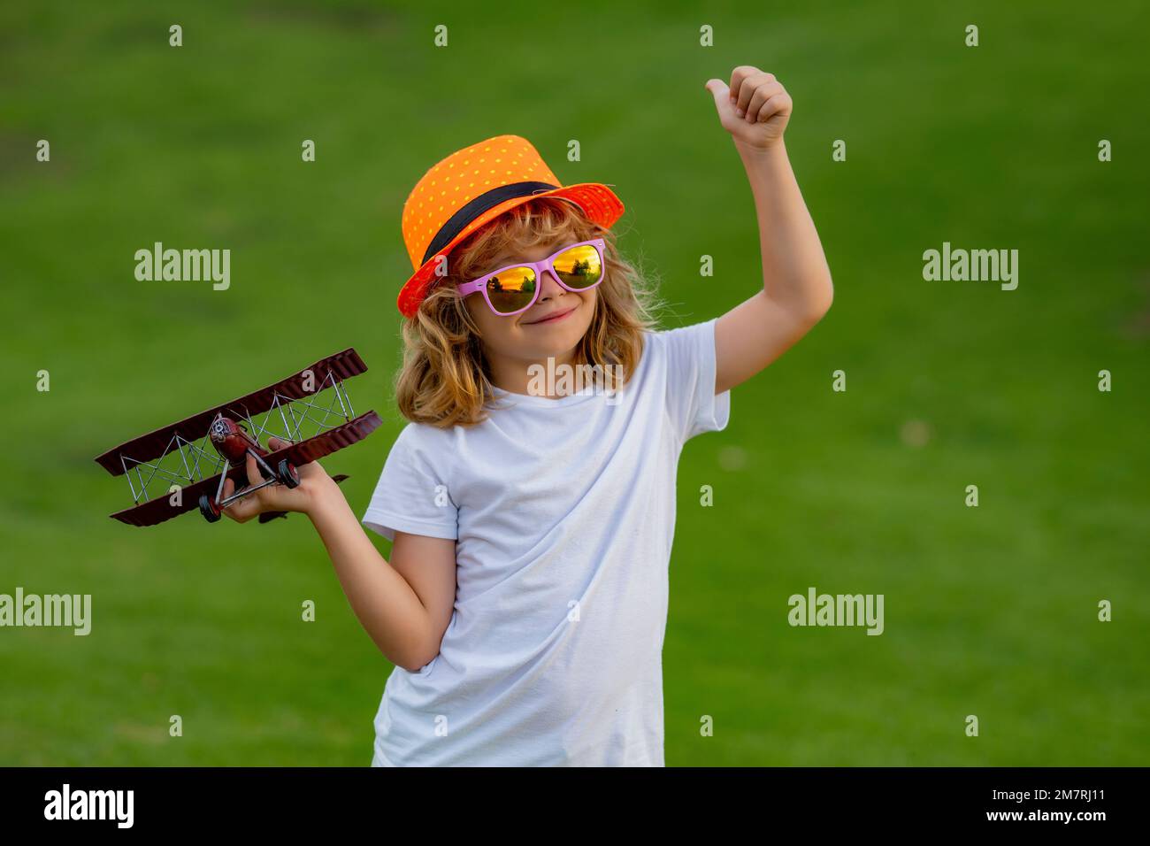 Kid having fun with toy airplane in field. Child pilot aviator with ...