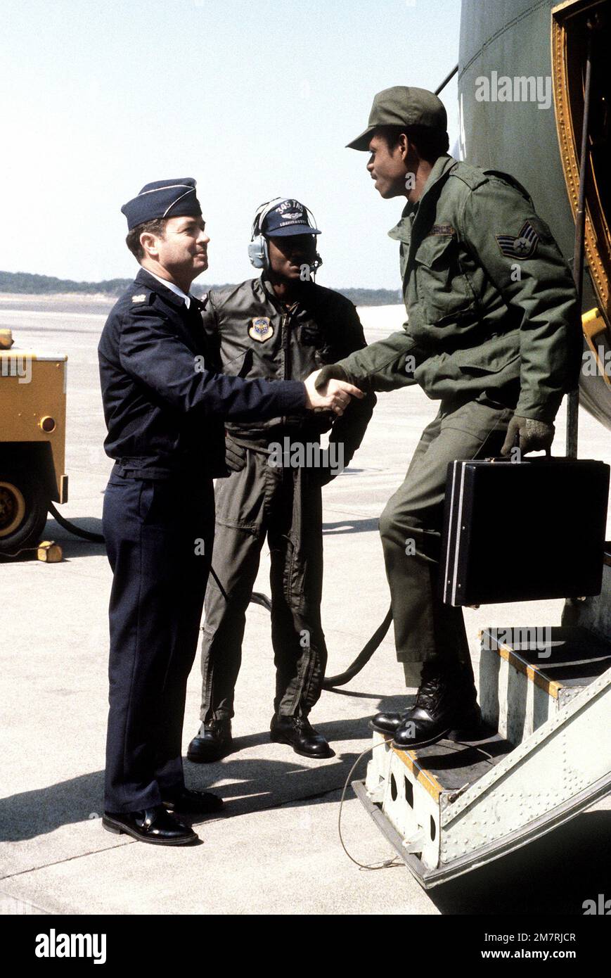 A ground support crew member arrives aboard a C-130 Hercules aircraft ...