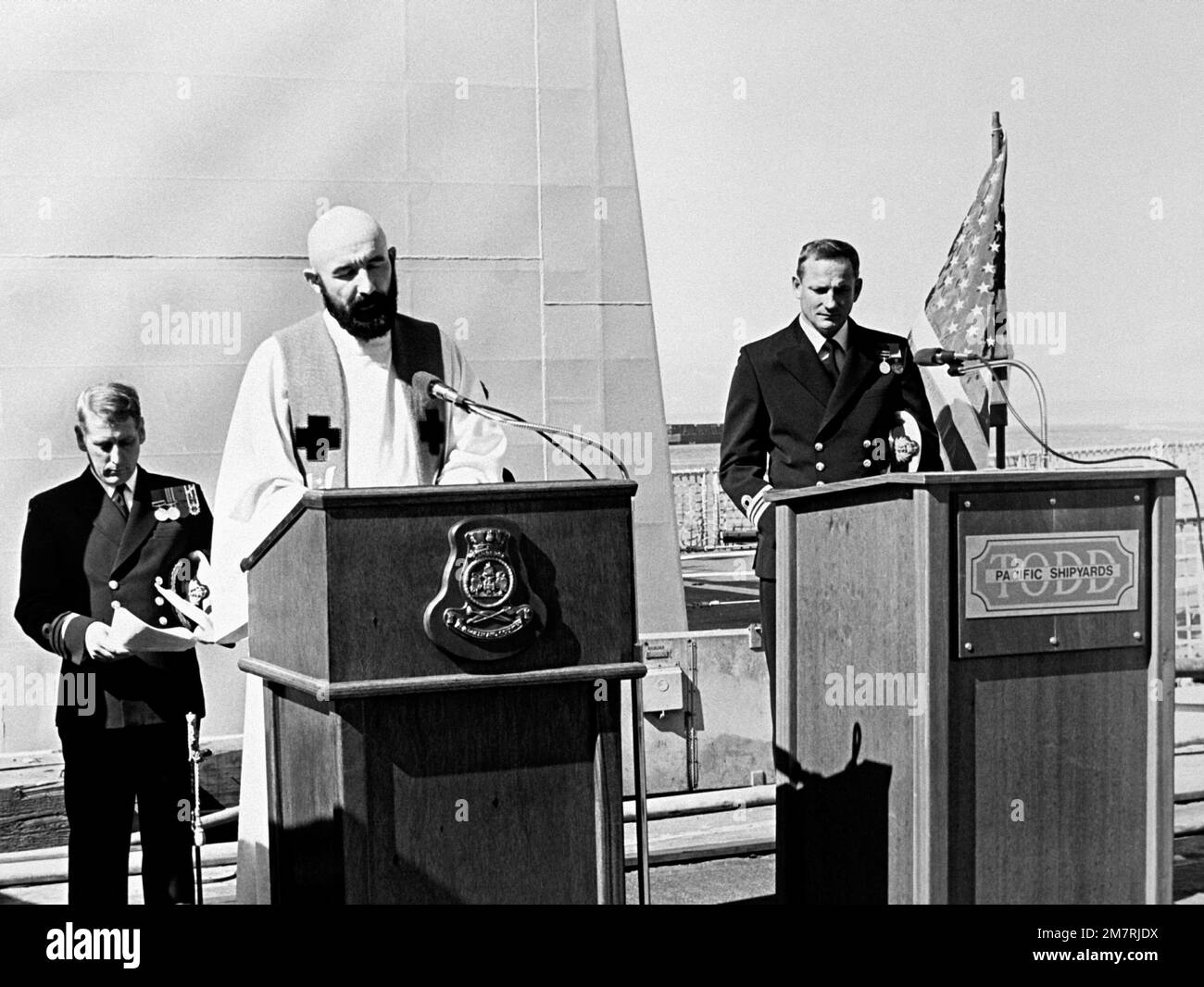 Chaplain (Cmdr.) Keely, USN, gives an invocation at the commissioning ...