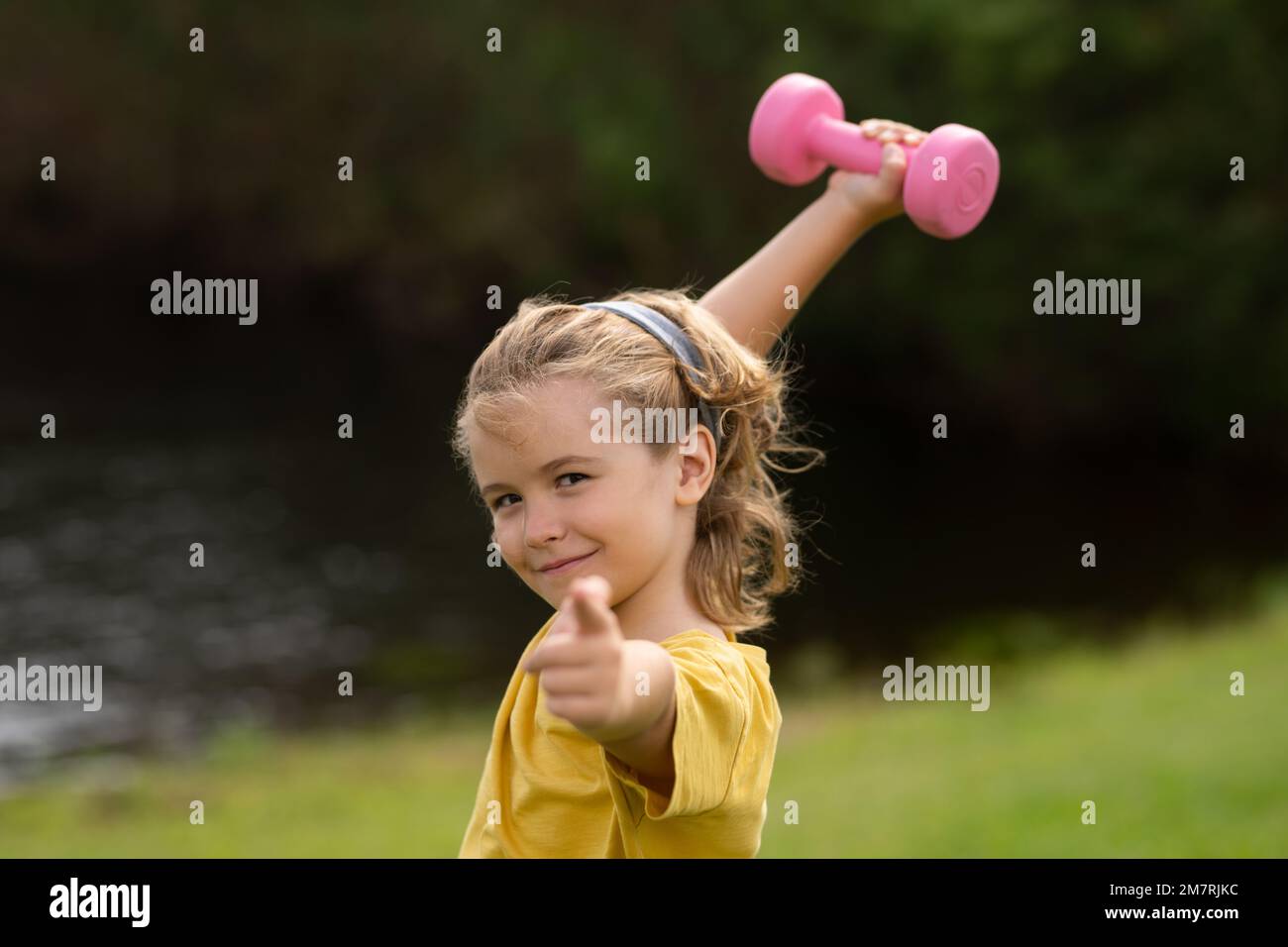 Sport activities at leisure with children. Blonde boy holding dumbbells. Sports exercises for ...