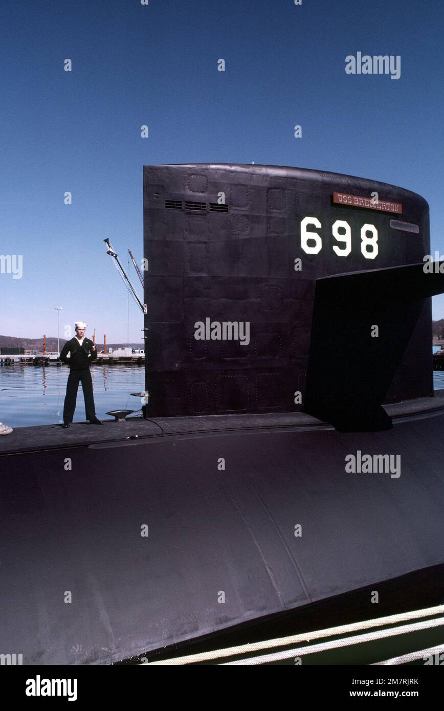 A crewman stands at parade rest aboard the nuclear-powered attack ...