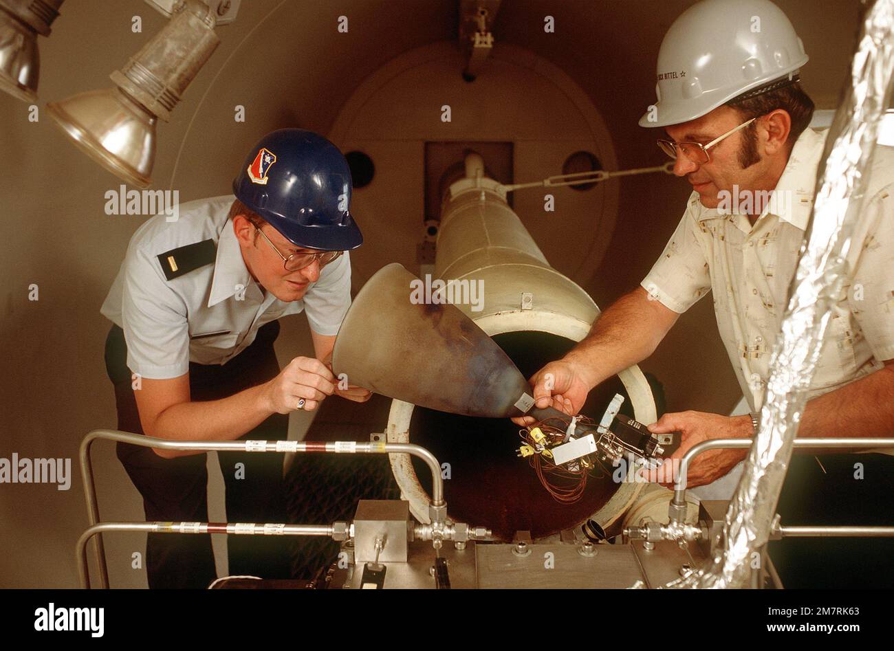 Engineers inspect a 50-pound thrust engine after firing it in its ...