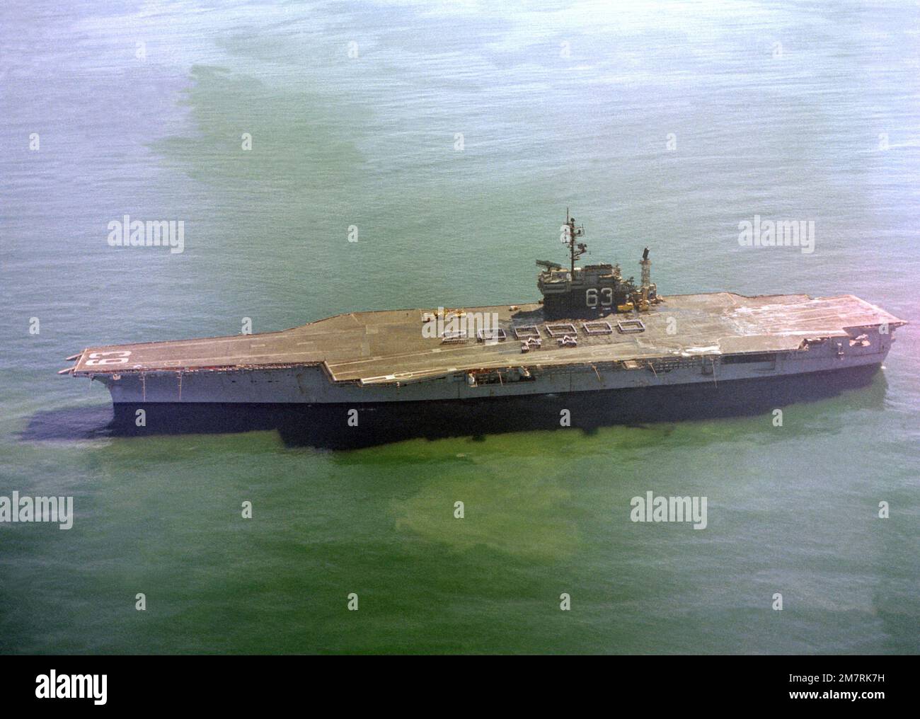 A port view of the USS KITTY HAWK (CV-63) as crewmen form the number ...
