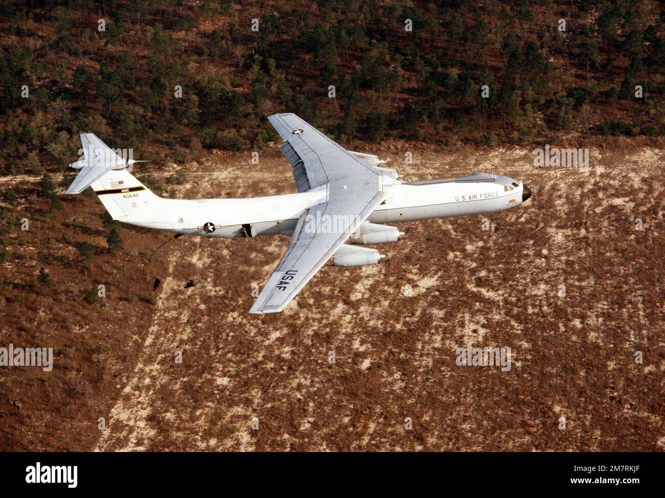 AN air-to-air right side view of a C-141B Starlifter aircraft dropping ...