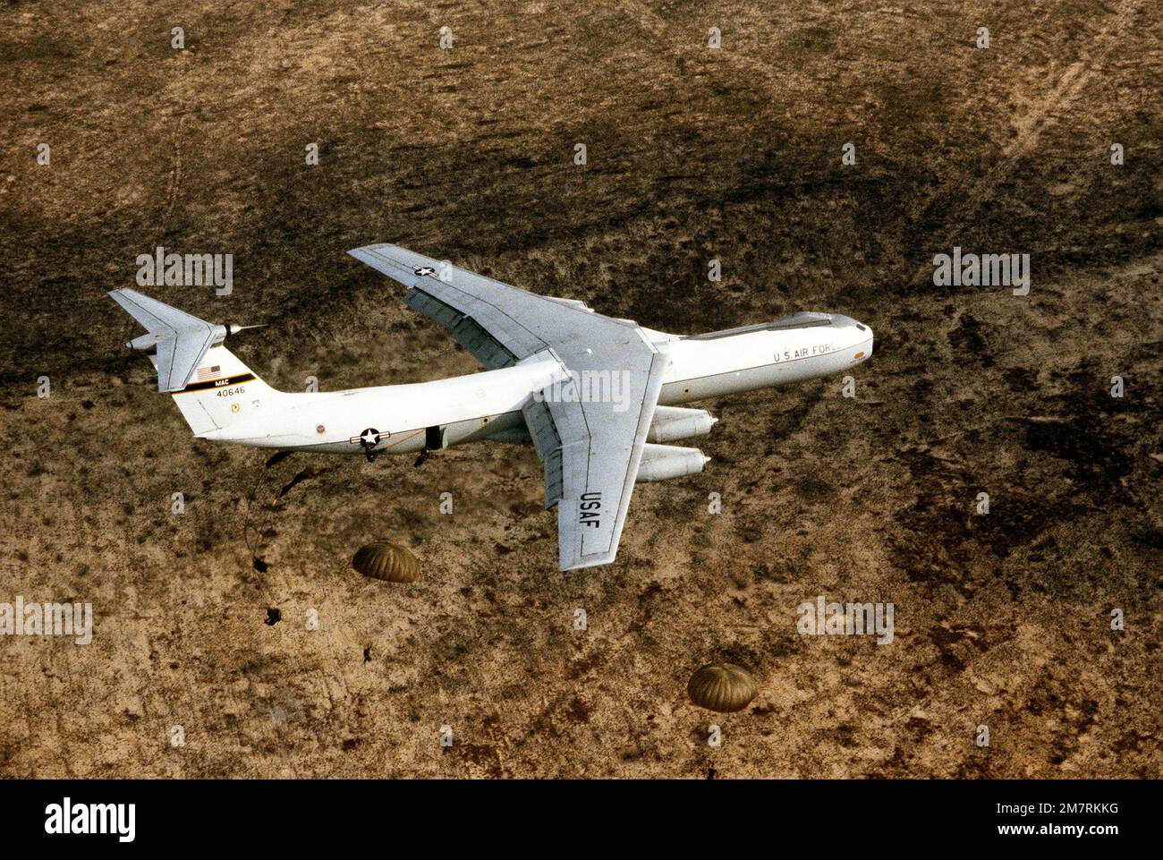 AN air-to-air right side view of a C-141B Starlifter aircraft dropping ...