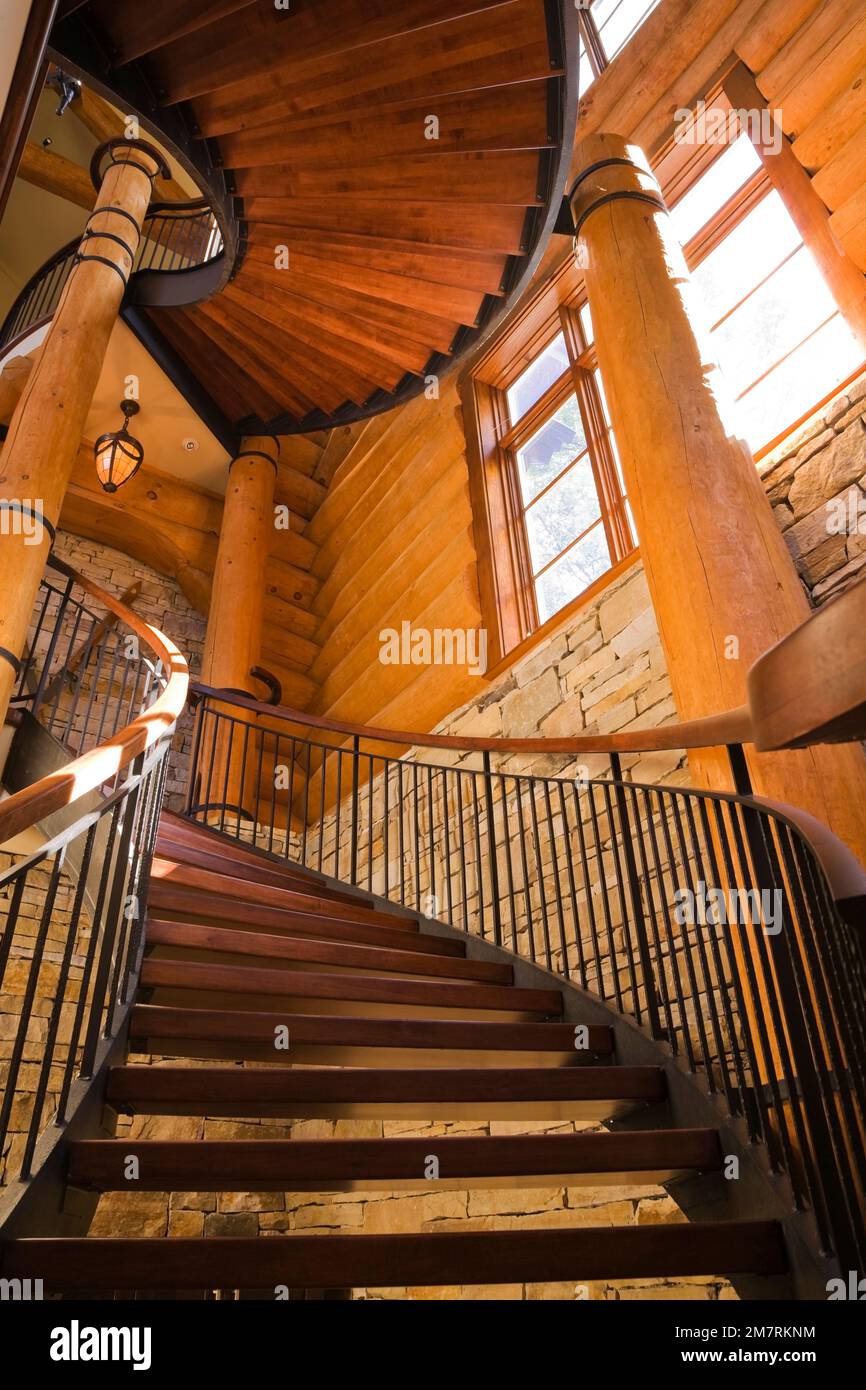 Curved and spiraling wood and wrought iron staircase leading to main ...