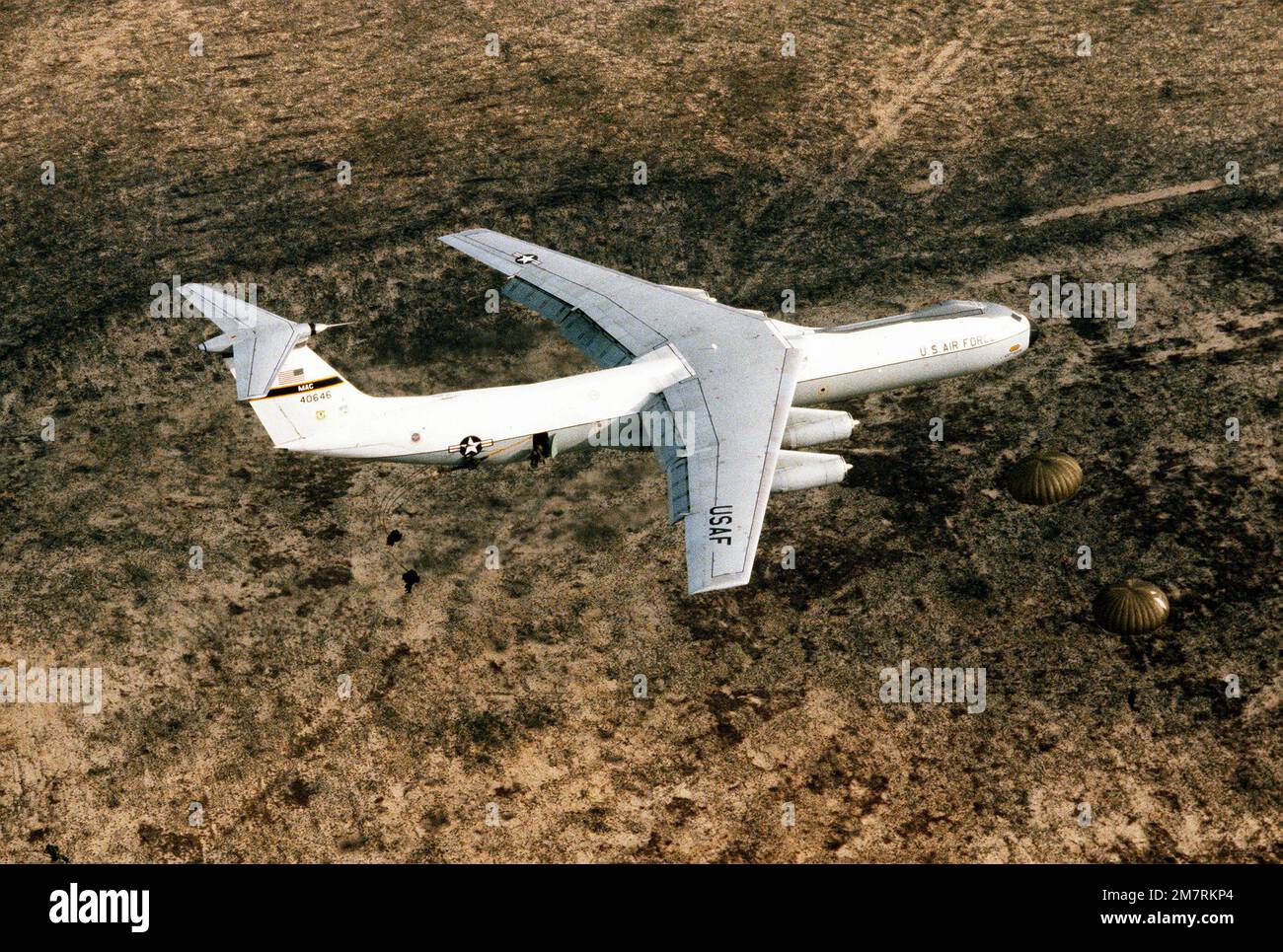 AN air-to-air right side view of a C-141B Starlifter aircraft dropping ...