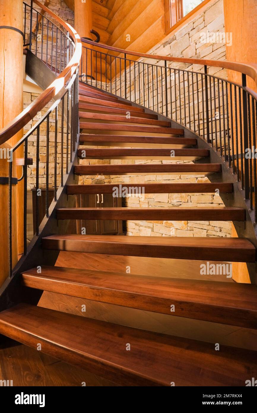 Curved and spiraling wood and wrought iron staircase leading to main ...