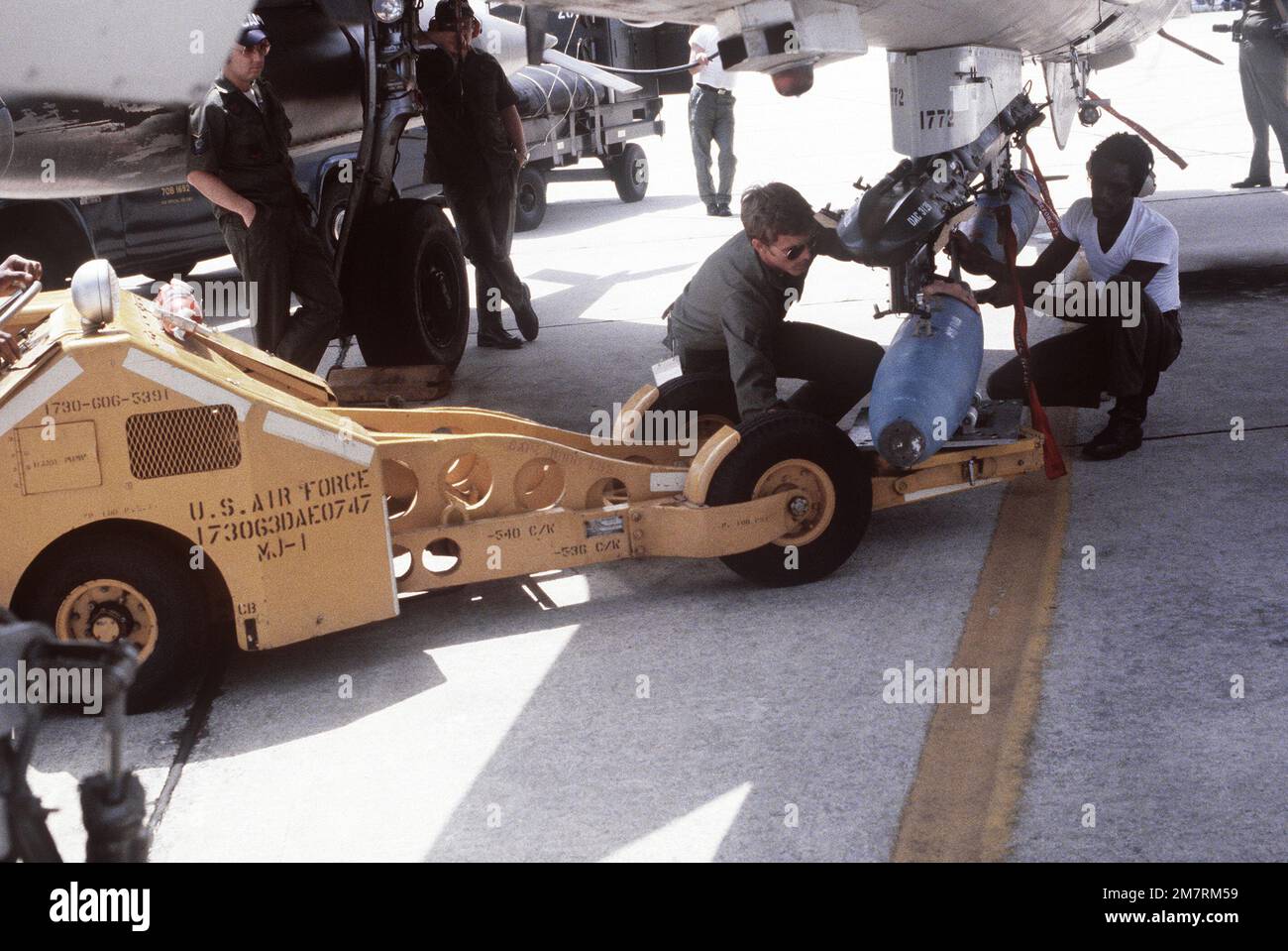 A crew loads a 500-lb. Mark 82 bomb on an F-4 Phantom II aircraft, with ...