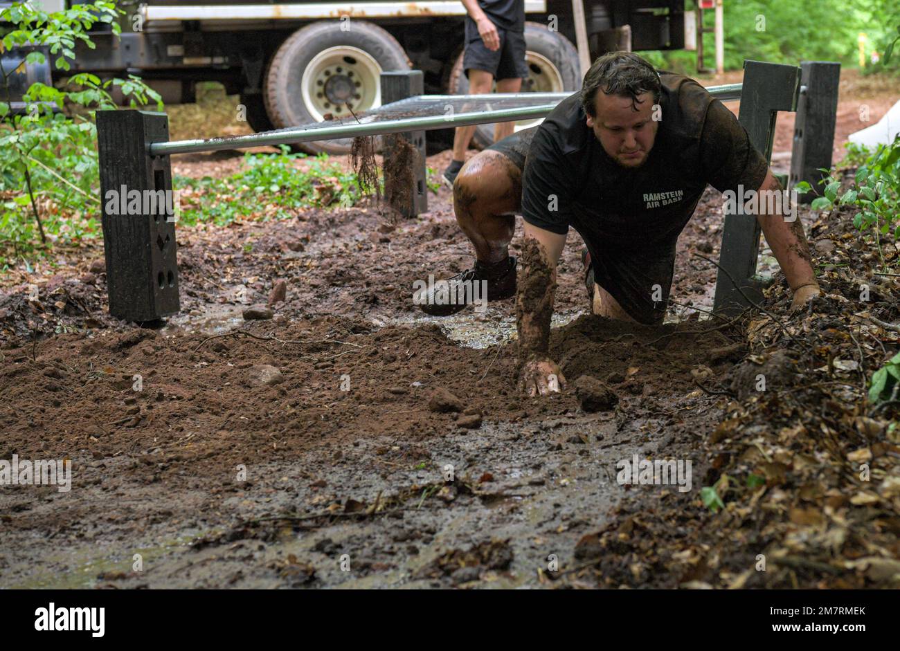 A Legendary Mud Run participant exits a low-crawl obstacle in the mud ...