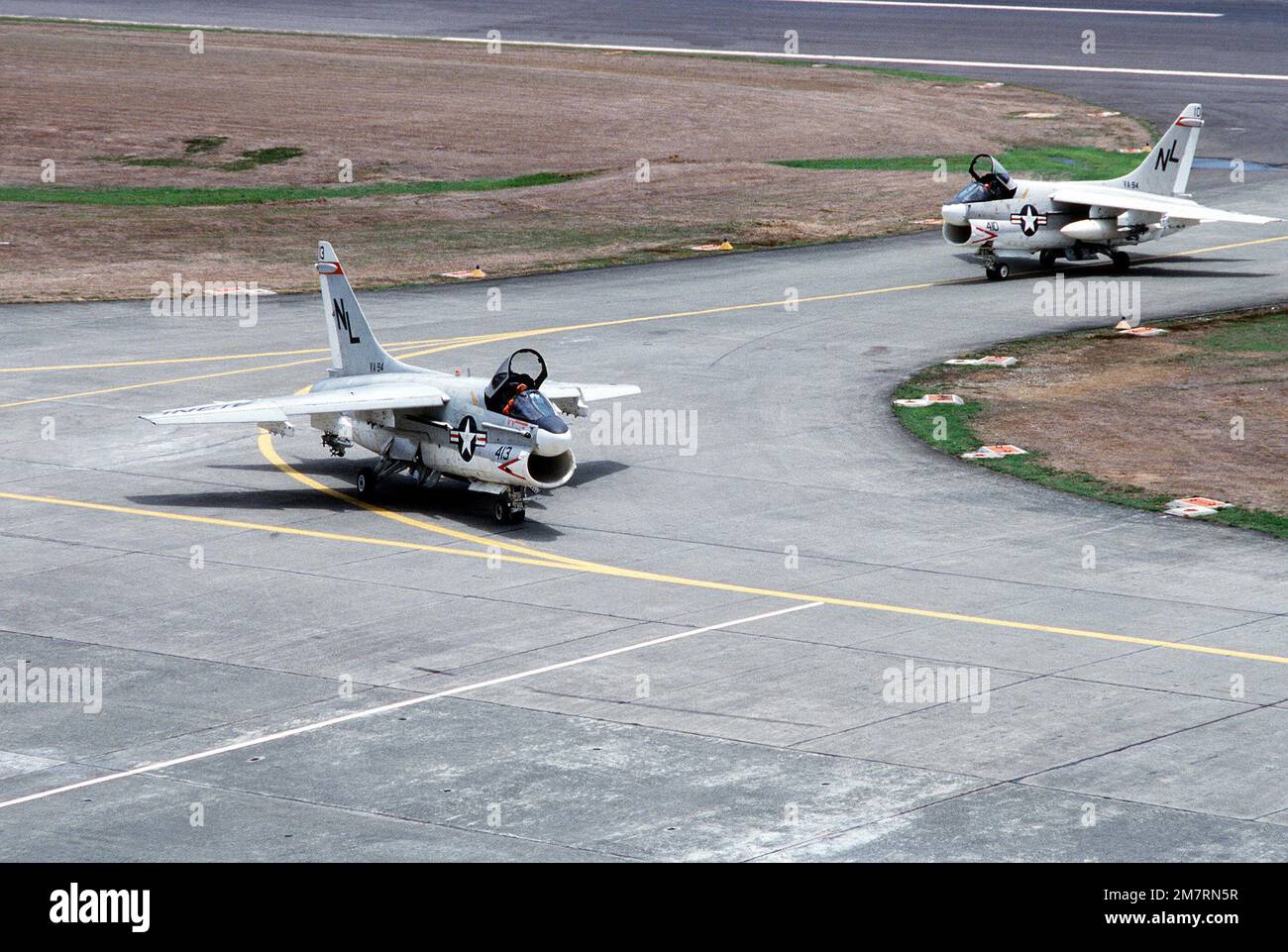 Two Attack Squadron 94 (VA-94) A-7E Corsair aircraft taxi off a runway ...