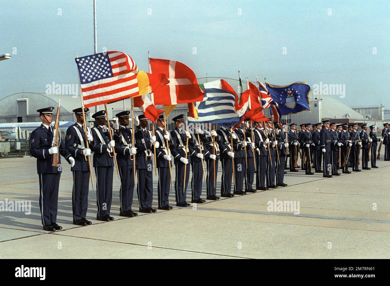 An honor guard, holding flags of NATO countries, perform at a ceremony ...
