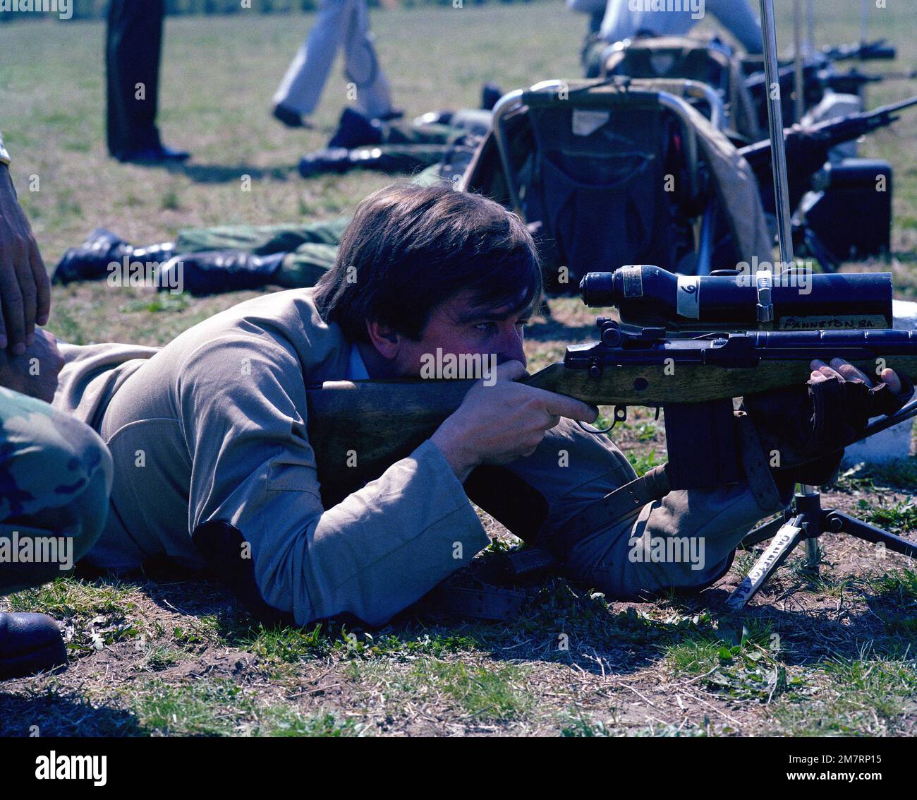 Secretary of the Navy John F. Lehman Jr. fires an M-14 rifle during his ...
