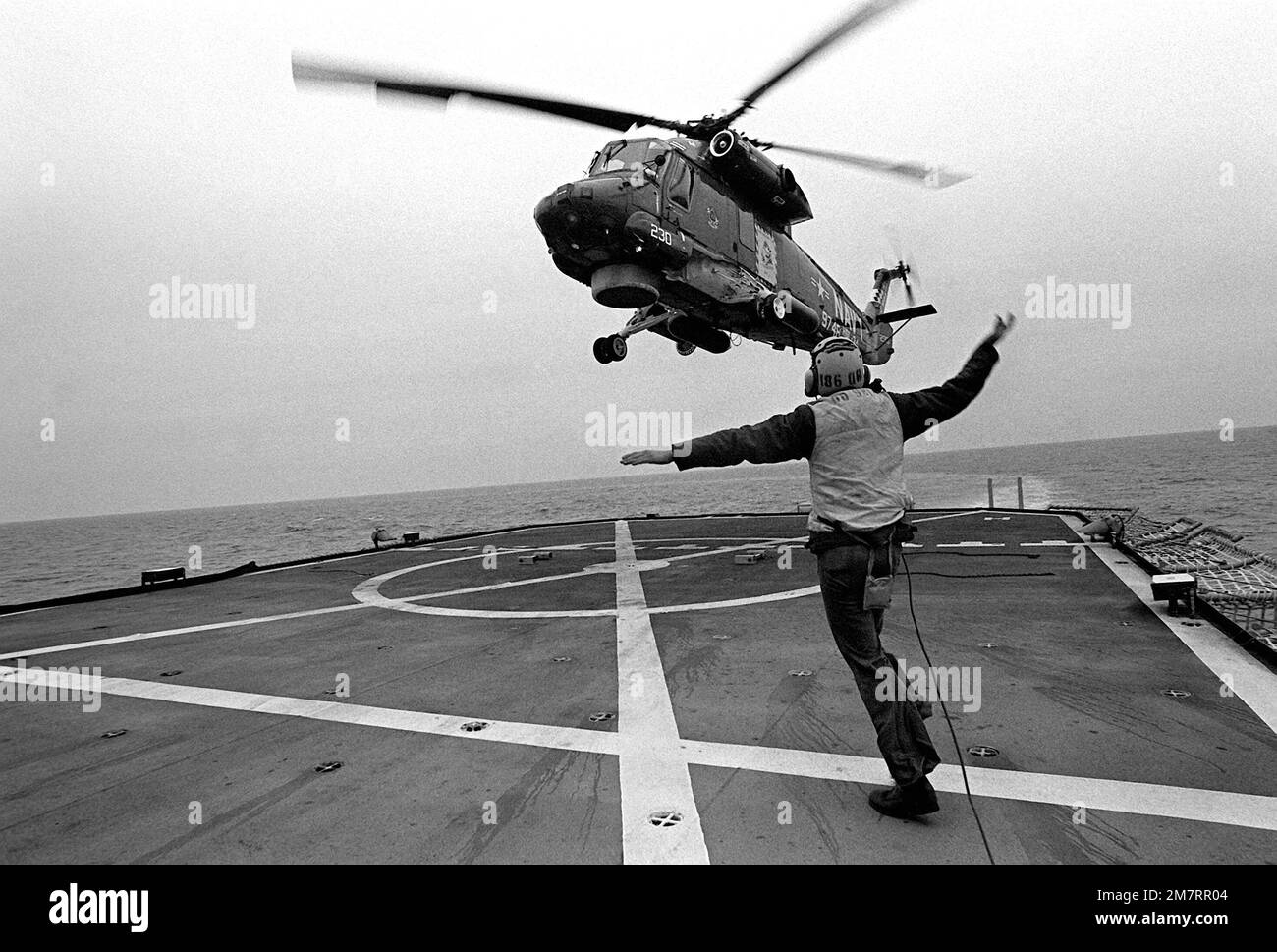 A flight deck crewman signals to an SH-2 Seasprite light airborne multi ...