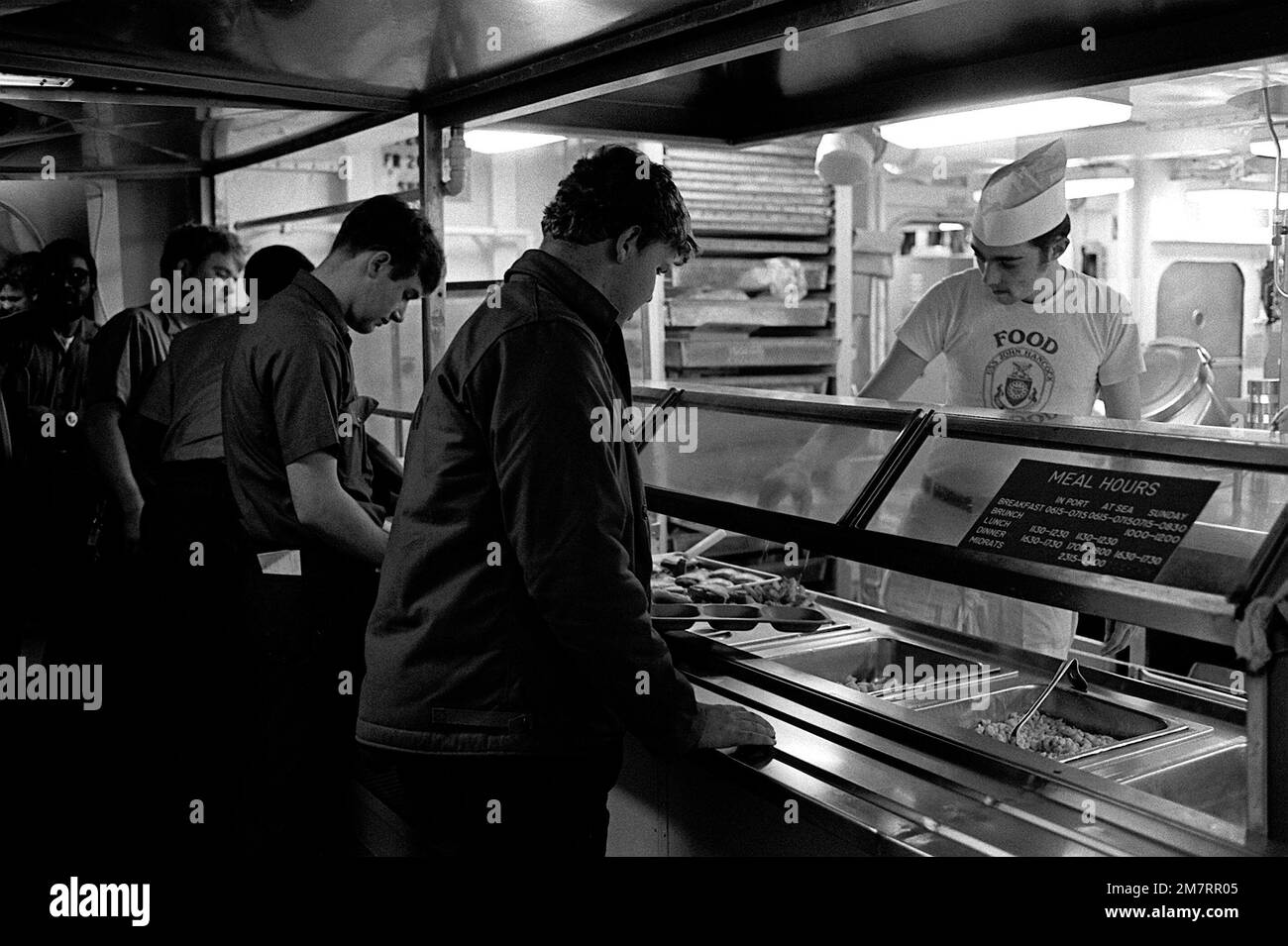 Crewmen go through the food line for the evening meal aboard the ...