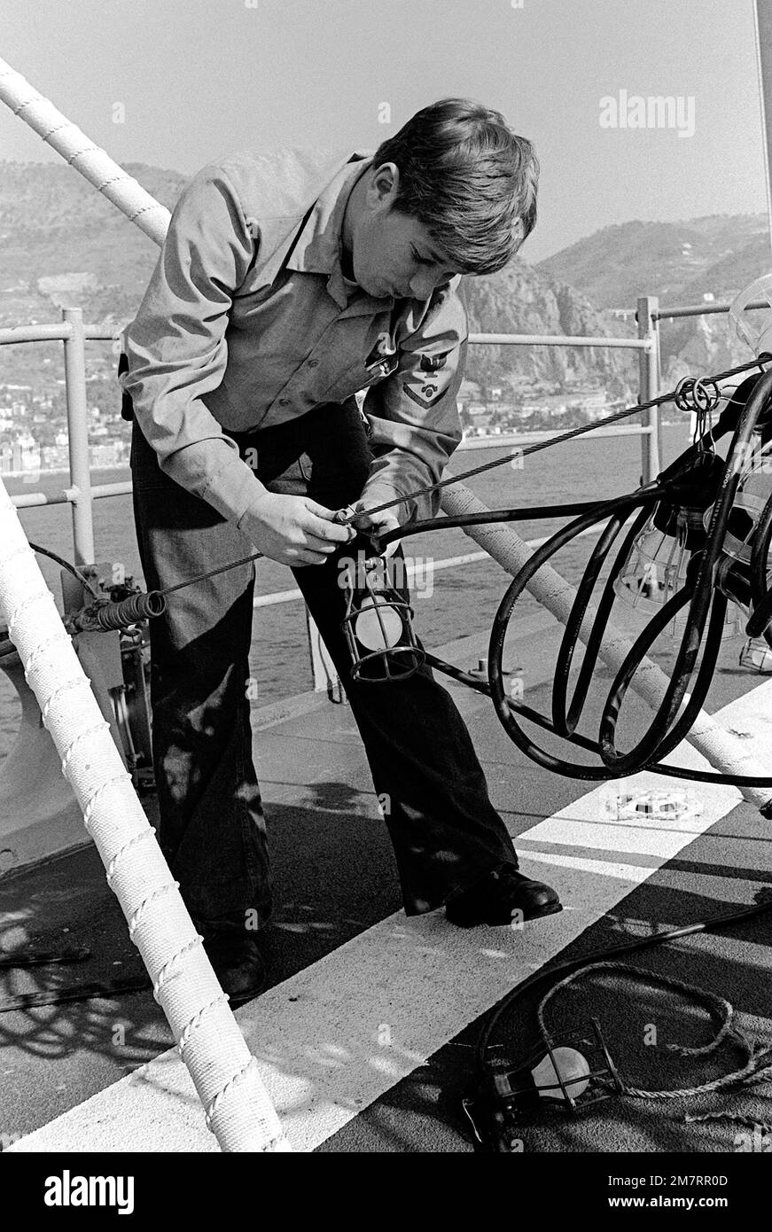 An electrician's mate third class rigs lights aboard the destroyer USS ...