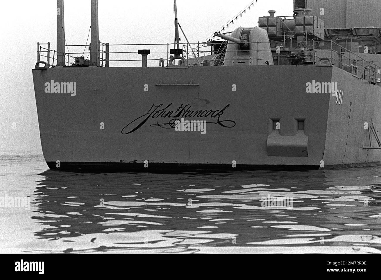 A stern view of the destroyer USS JOHN HANCOCK (DD-981) anchored during ...