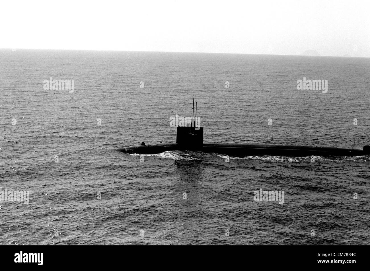 A port beam view of a nuclear-powered submarine underway. Base: Pearl ...