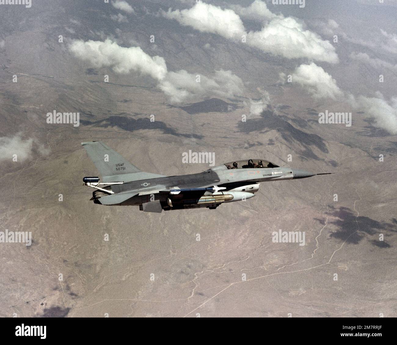 An air-to-air right side view of an F-16B Fighting Falcon aircraft with ...