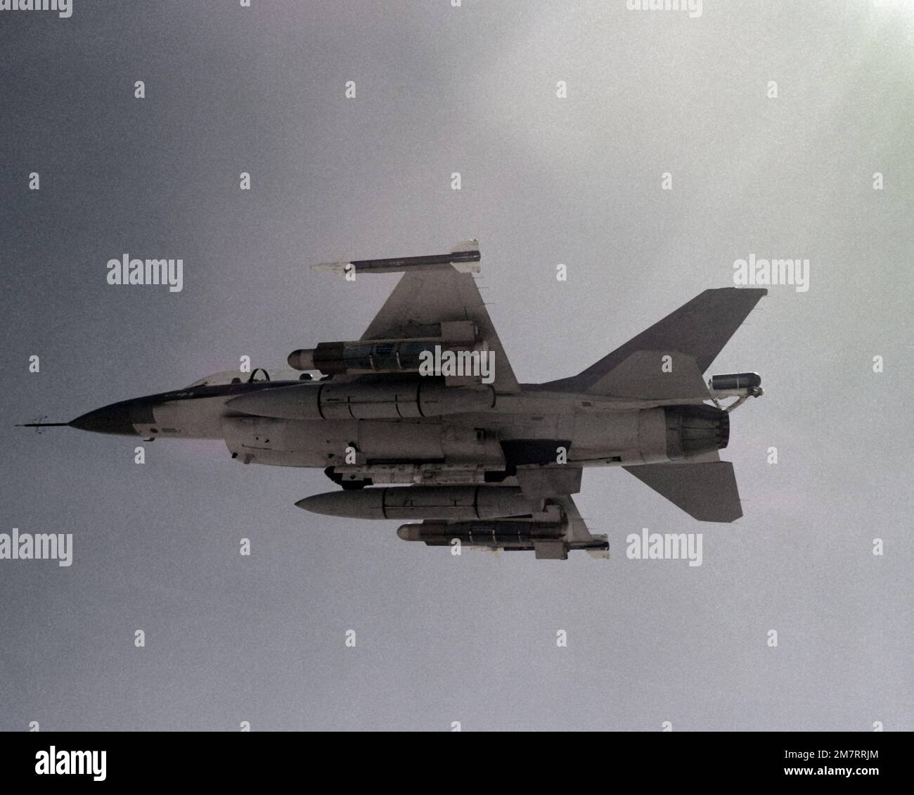 An air-to-air left underside view of an F-16B Fighting Falcon aircraft ...
