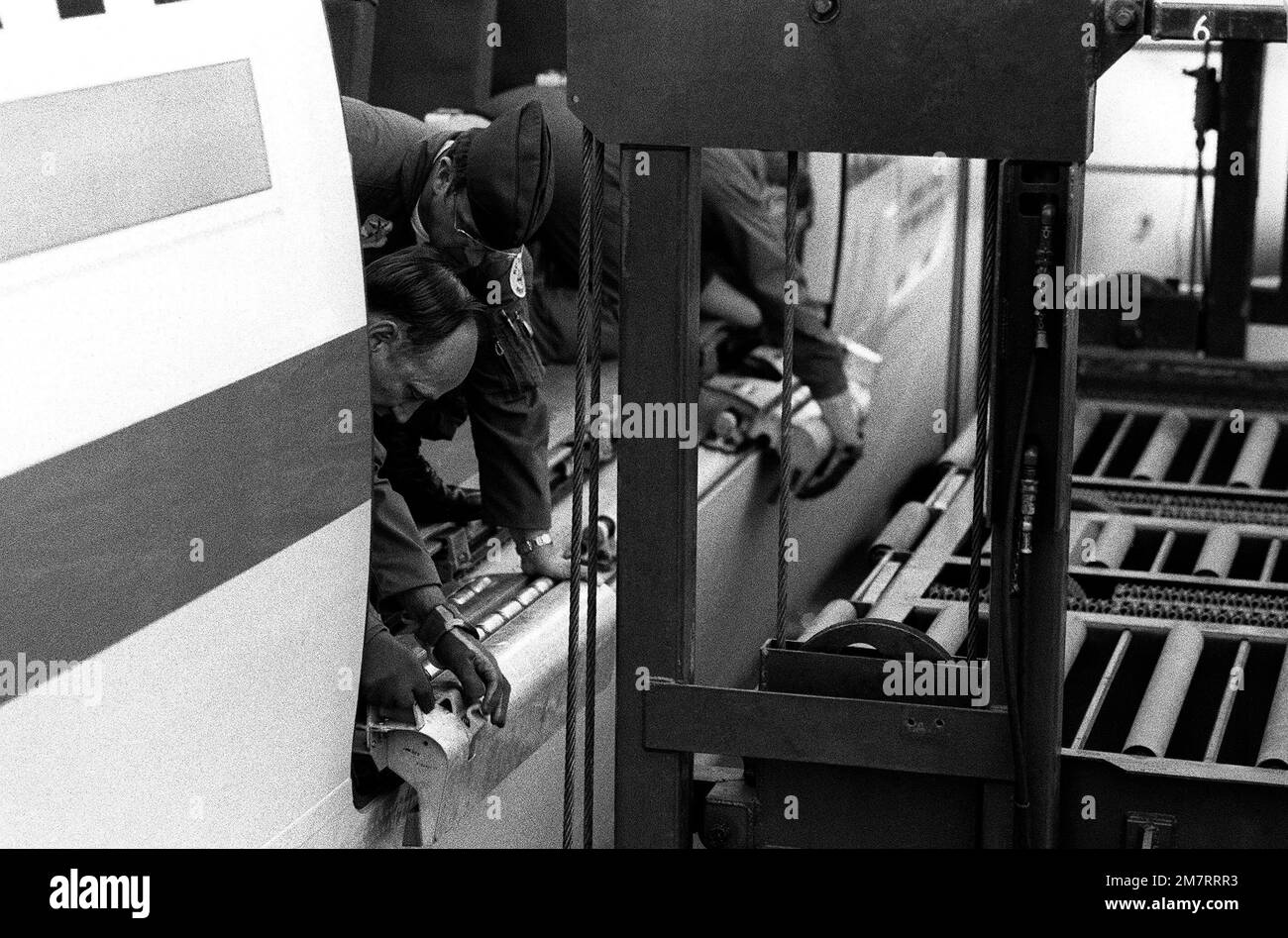 Crewmen attach a Cochran Loader to the cargo door of a KC-10 Extender ...