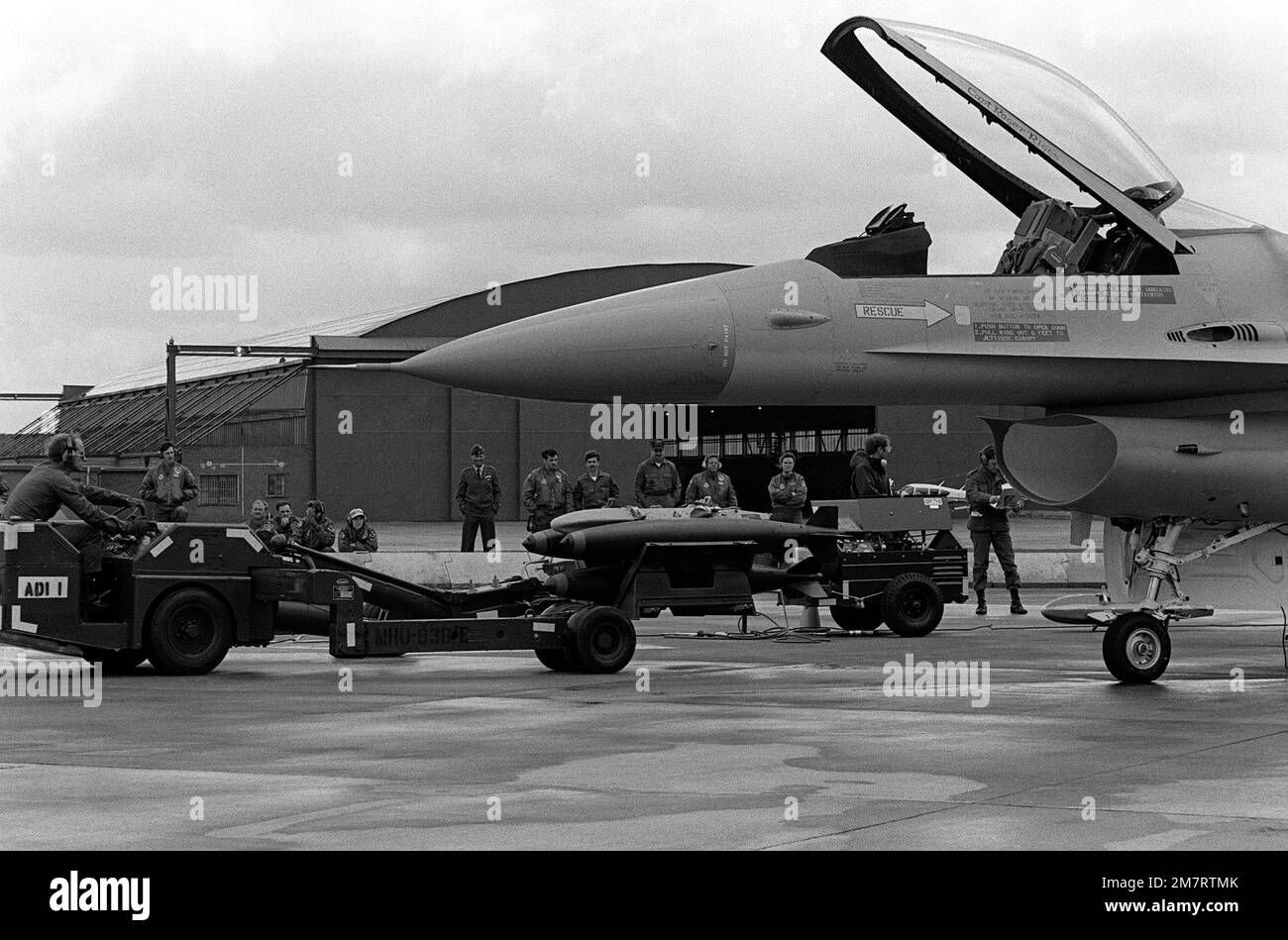 Bombs are moved into position near an F-16 Fighting Falcon aircraft ...
