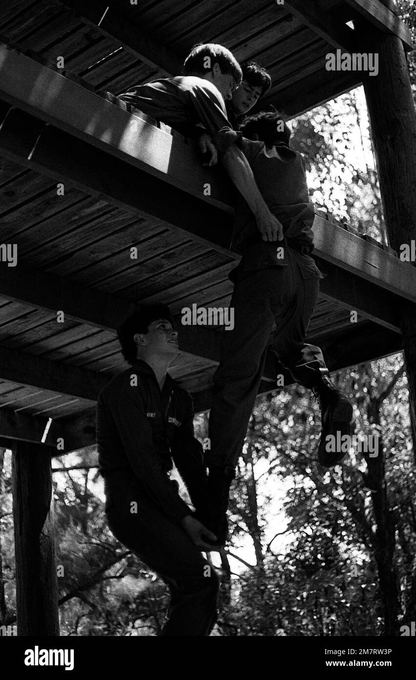Airmen climb up a tower during obstacle training in a civil air patrol ...