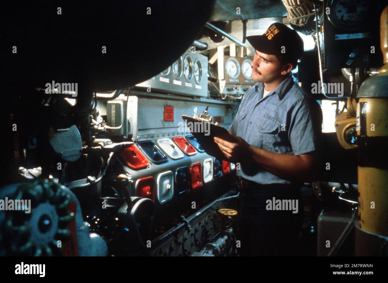 A technician checks the diesel backup engine aboard the nuclear-powered ...