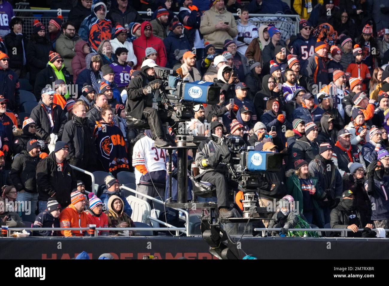 Fox television cameras work above the crowd during an NFL football game ...