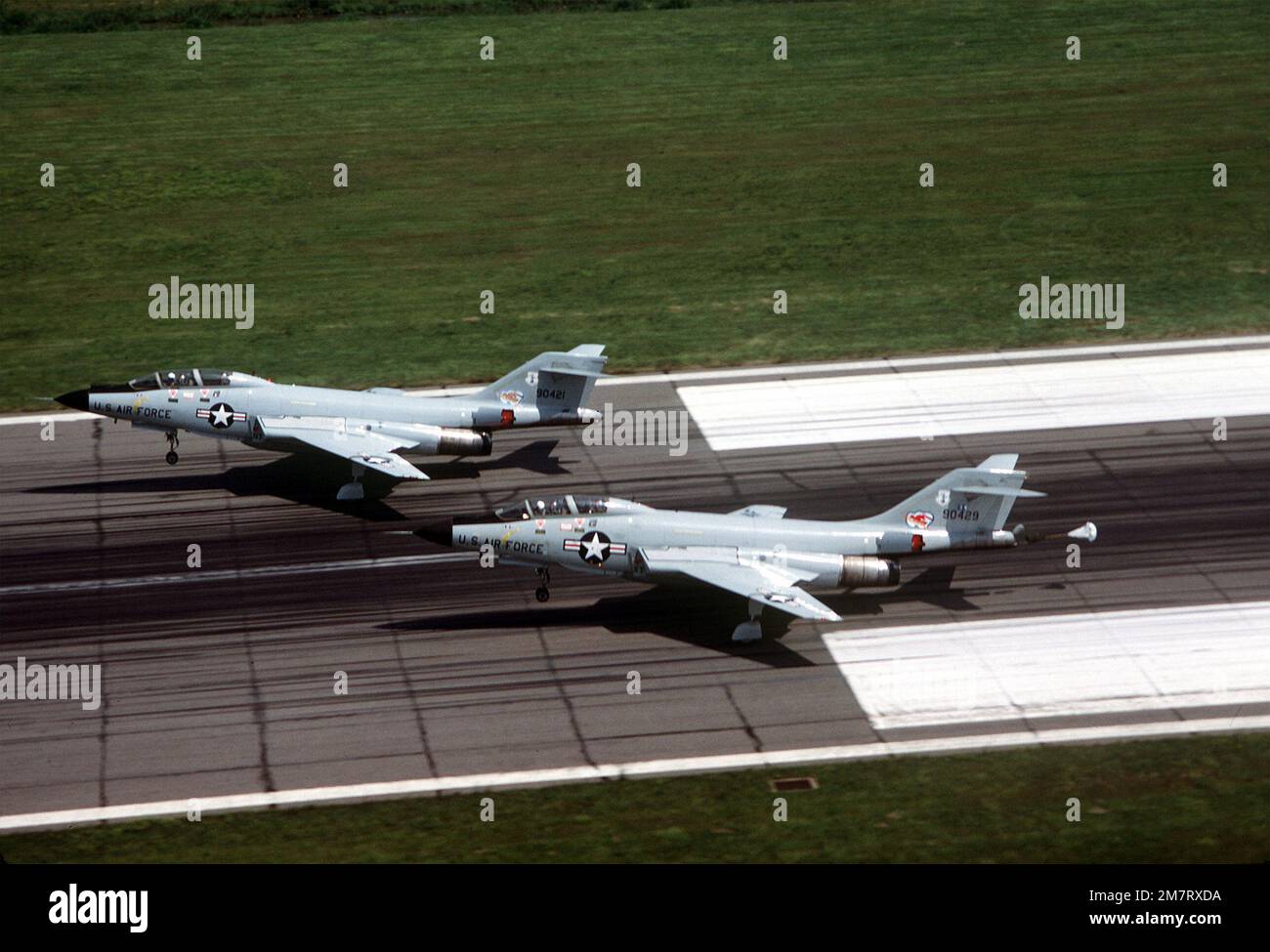 A left side view of two F-101 Voodoo aircraft's landing and starting to ...