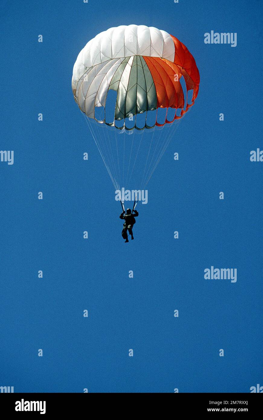 A pararescueman nears the ground after jumping from a C-130 Hercules ...