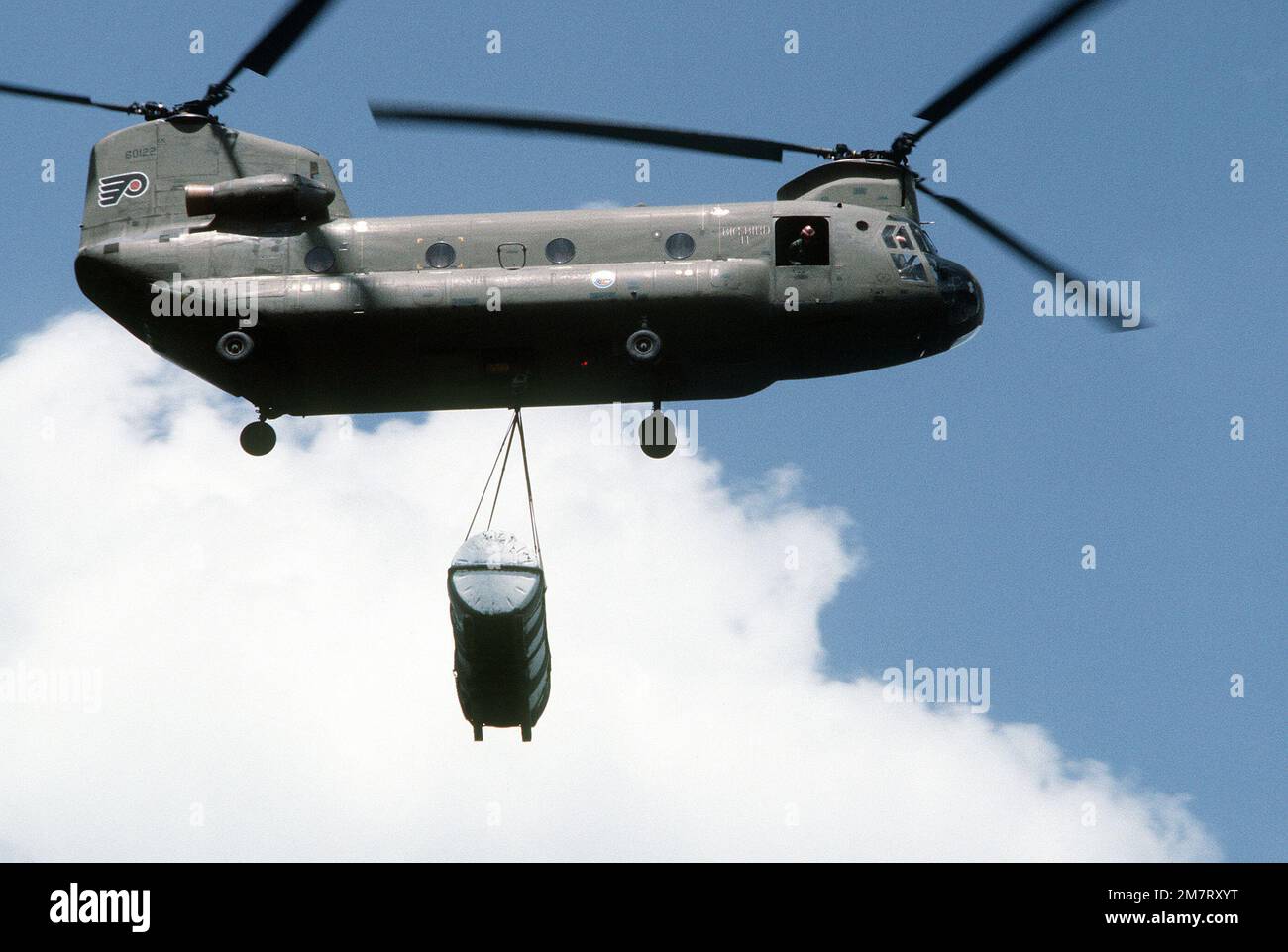 A right side view of an Army CH-48 Chinook helicopter hovering with ...