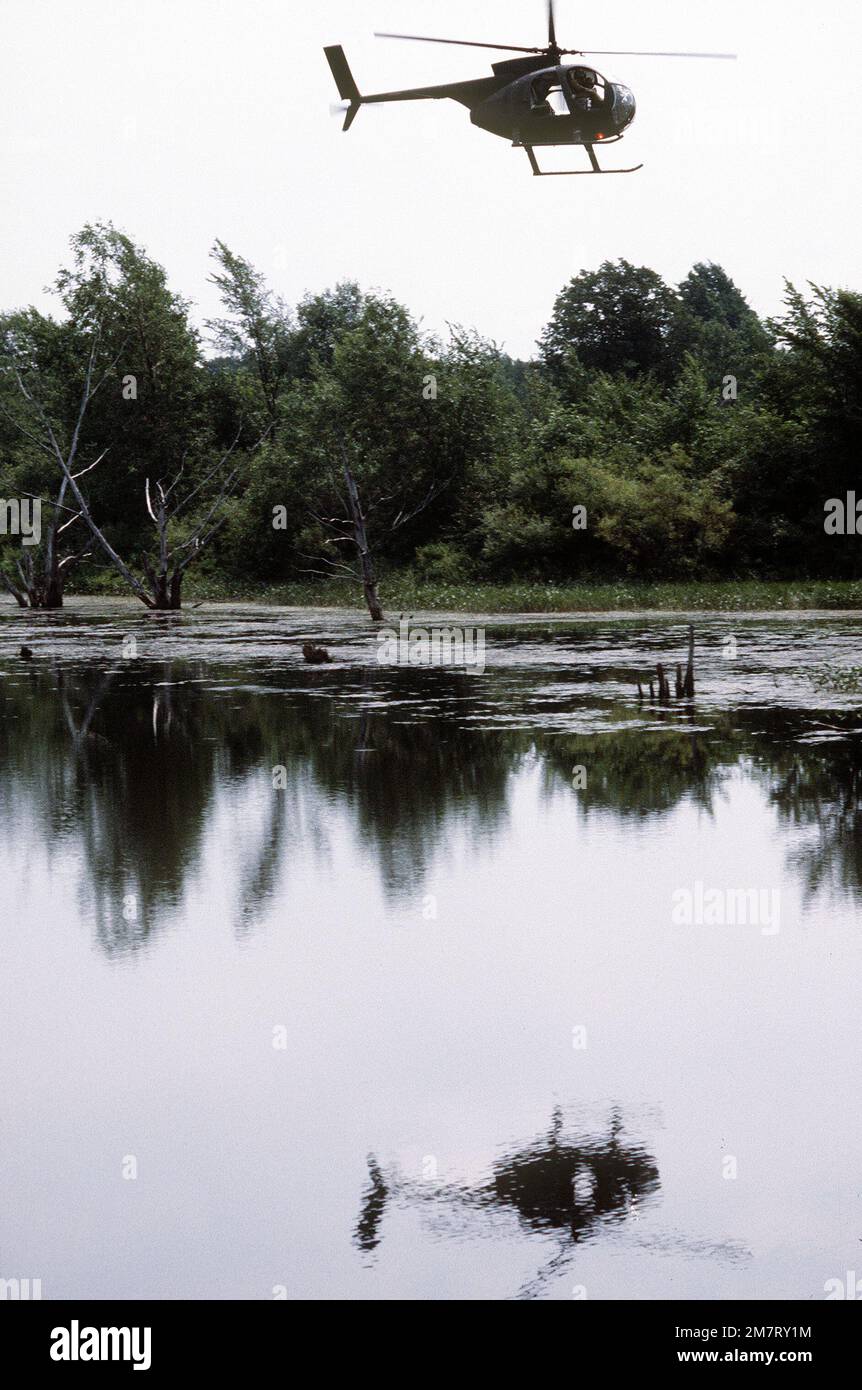 Right side view of an OH-6 Cayuse helicopter flying over the training ...