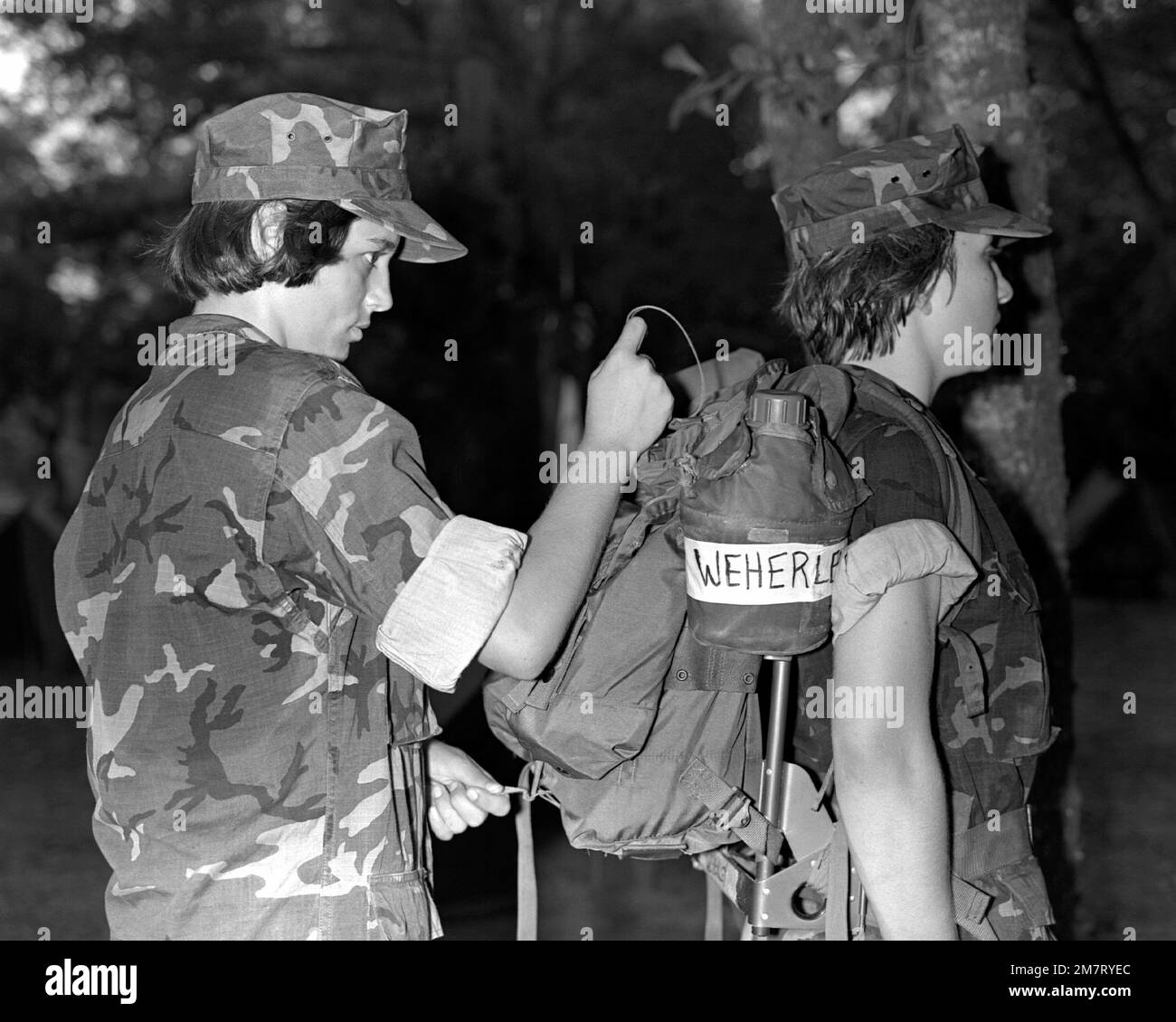 PVT. Lemieux adjusts PVT. Weherley's "Alice" pack during preparation ...