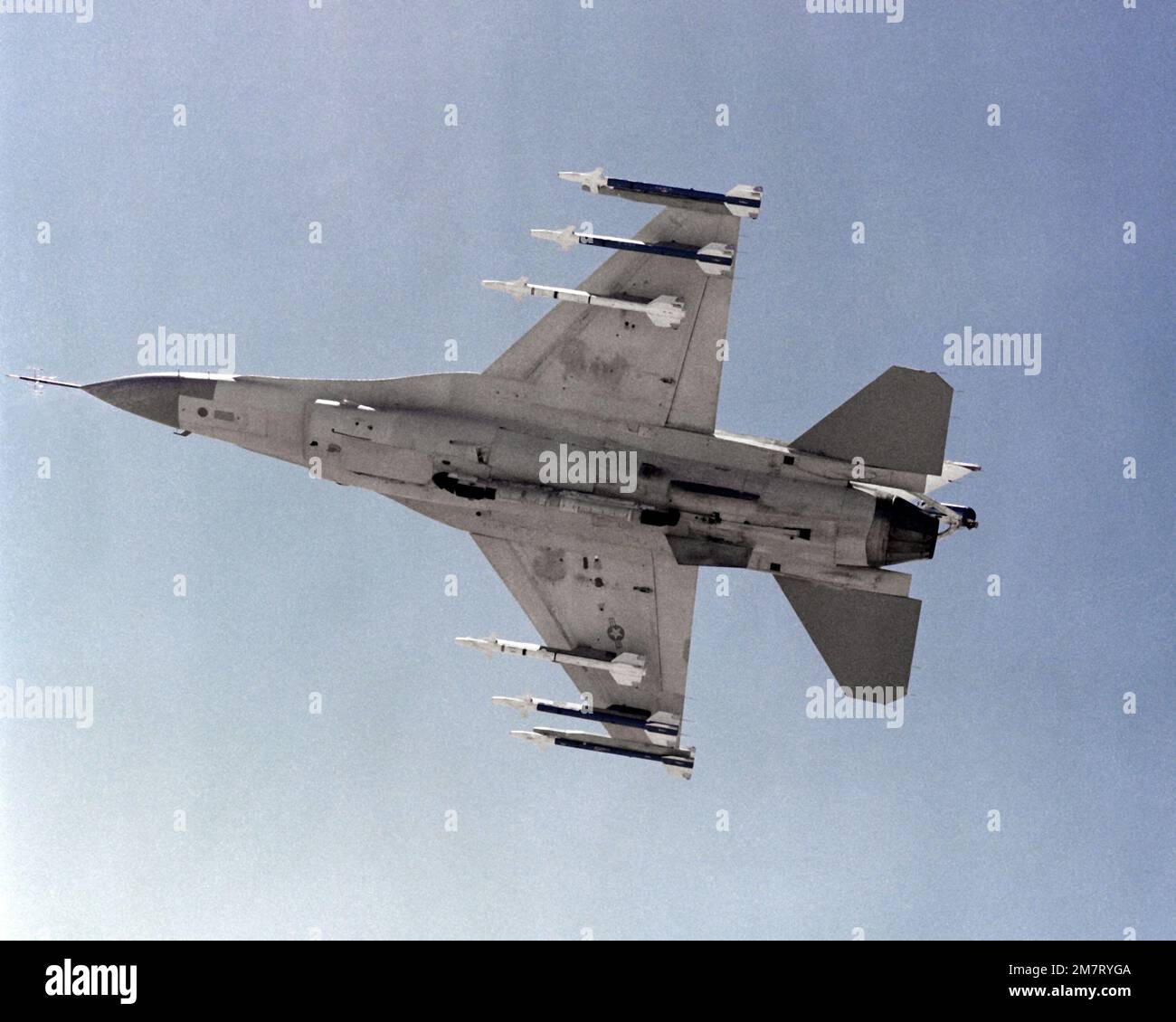 An air-to-air left side view of an F-16B Fighting Falcon aircraft with ...