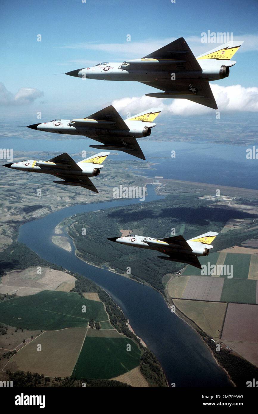AN air-to-air left side view of four F-106 Delta Dart aircraft in a ...