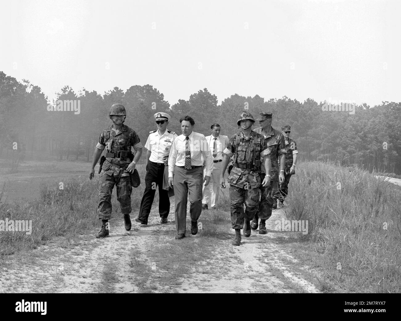 Secretary of Defense Caspar W. Weinberger is flanked by a Marine ...