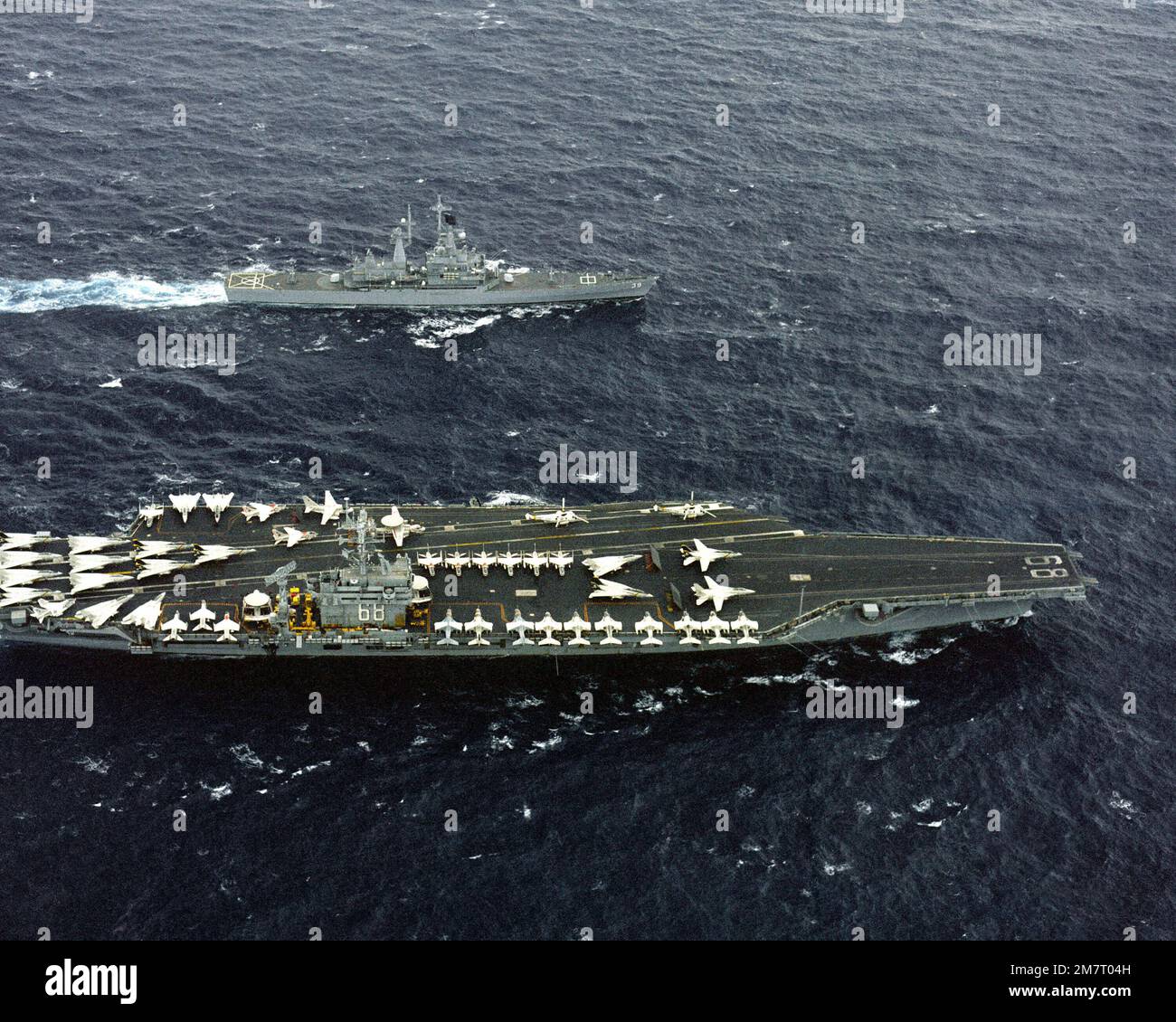 An aerial starboard beam view of the nuclear-powered aircraft carrier USS NIMITZ (CVN-68) and ...