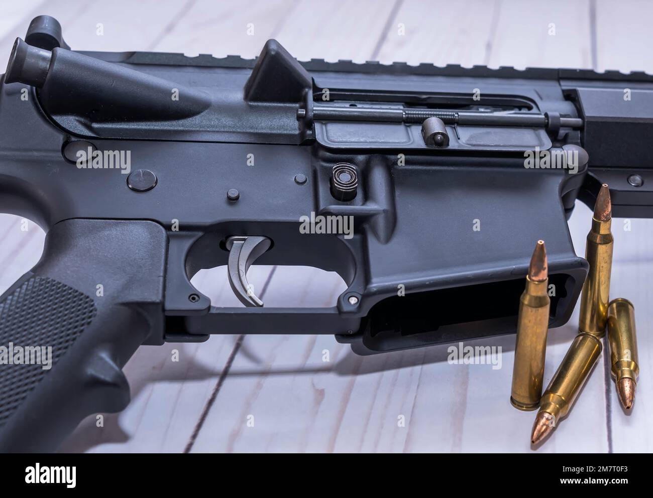 An AR15 rifle chambered in 223 caliber with four bullets next to it on ...