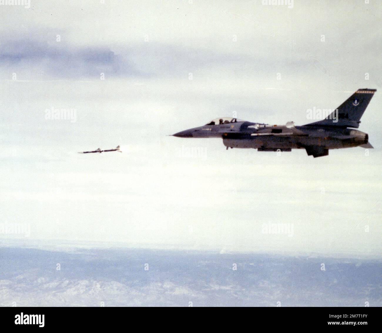 A left side view of an F-16 Fighting Falcon firing an advanced medium ...