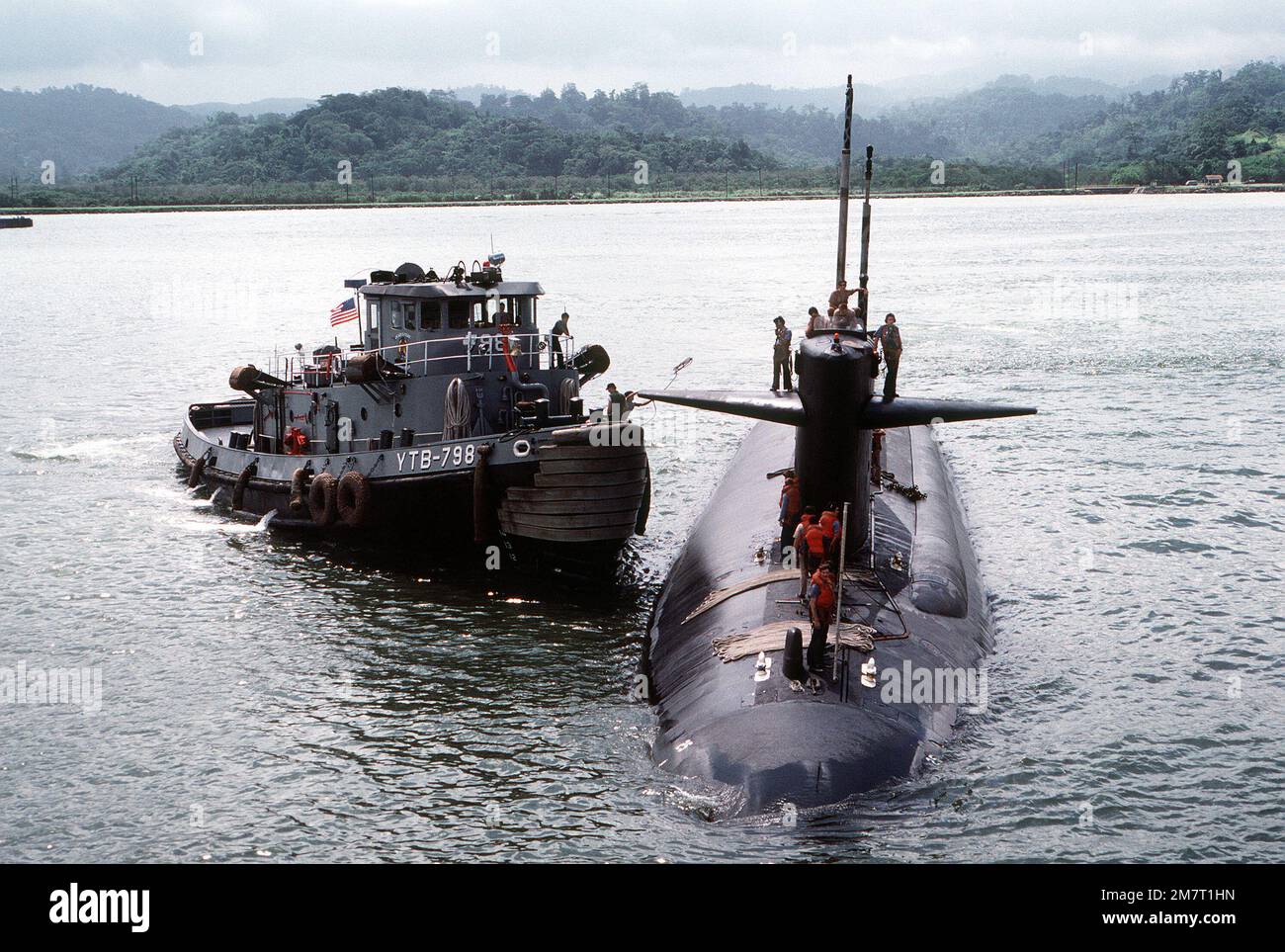 The large harbor tug OPELIKA (YTB-798) pulls up along the starboard ...