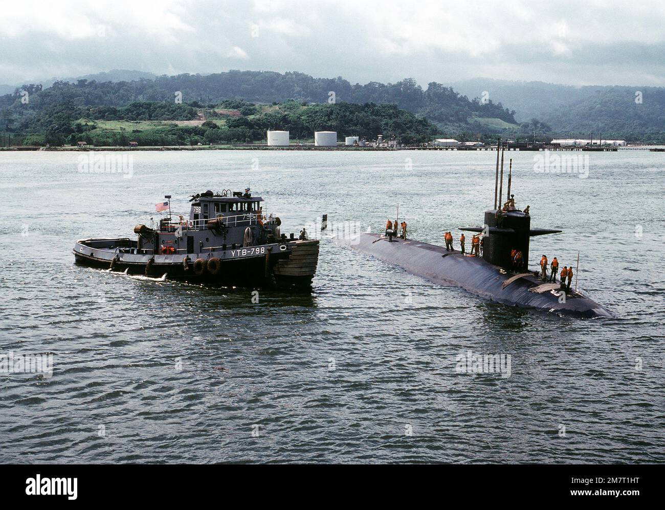 The large harbor tug USS OPELIKA (YTB-798) pulls up along the starboard ...