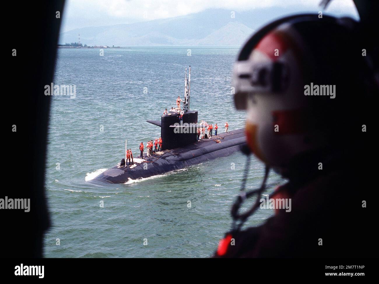 View from a helicopter of crewmen standing on the deck of the nuclear ...