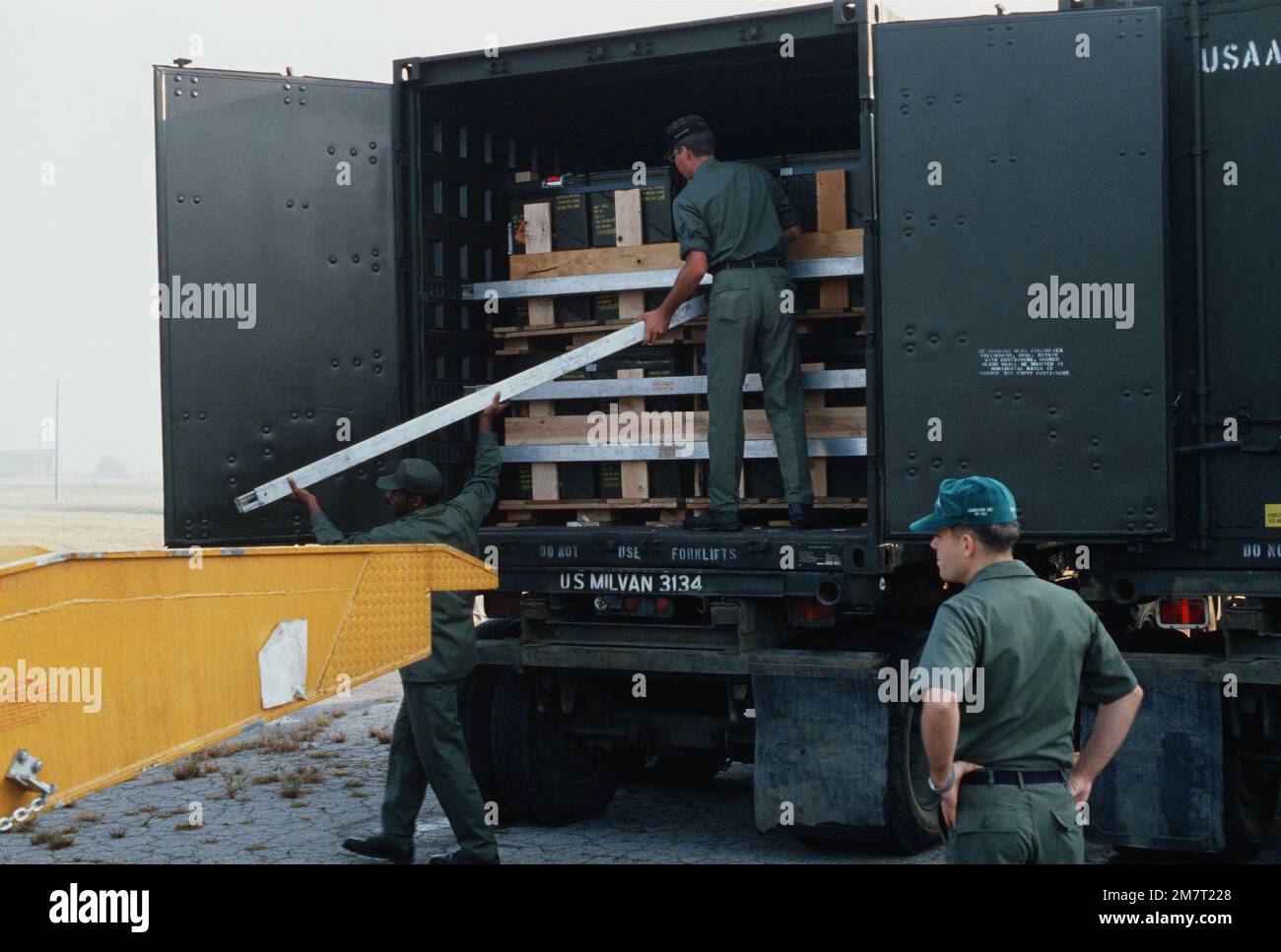 Aluminum retaining rails are removed from the rear of a military van ...
