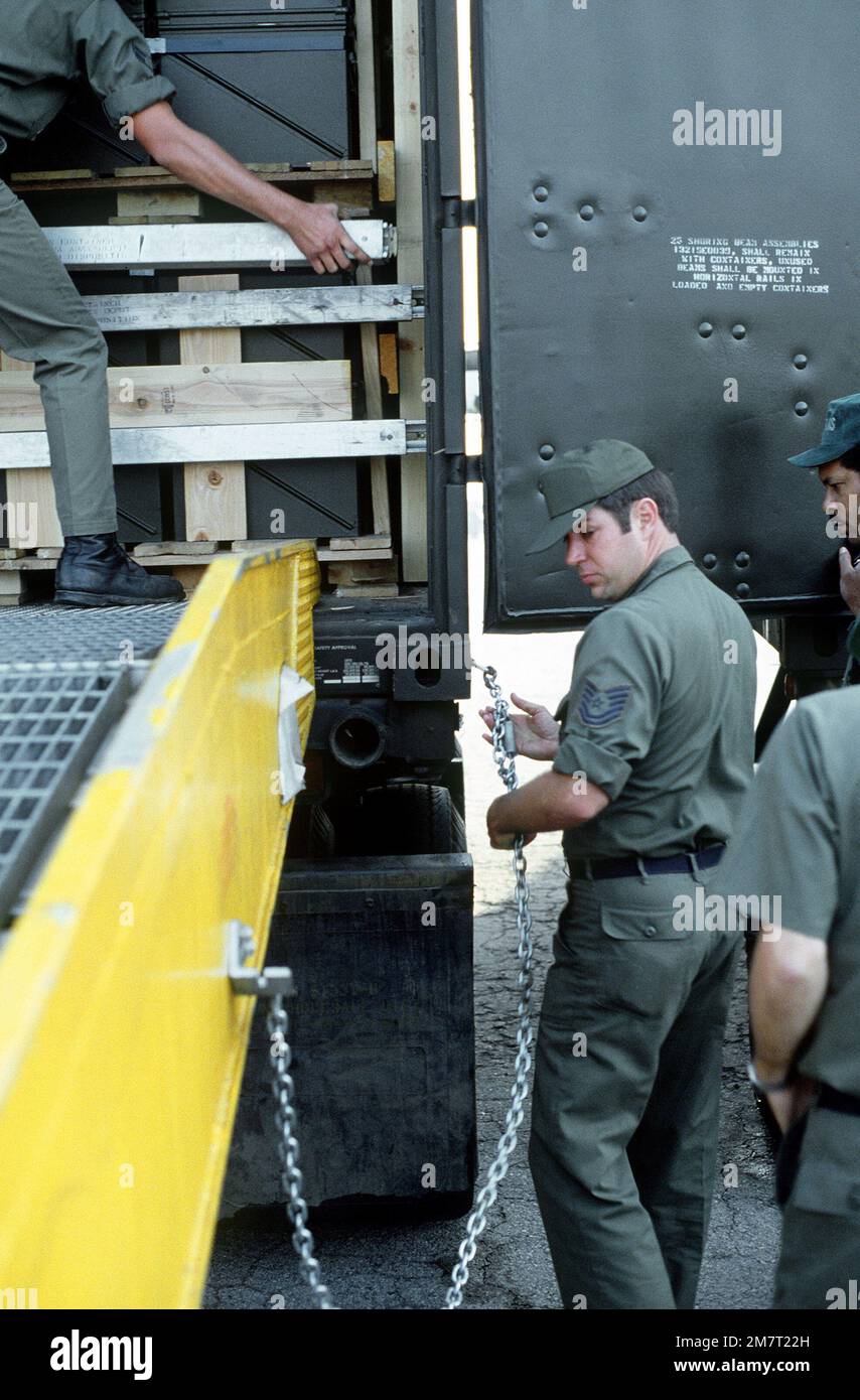 Mobile ramp safety chains are secured to a military van before it is ...
