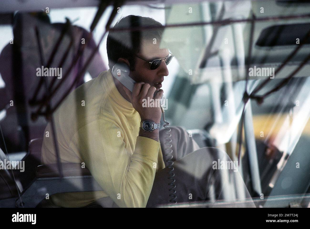 LCDR Gene Gilbert monitors flight operations by phone aboard the ...