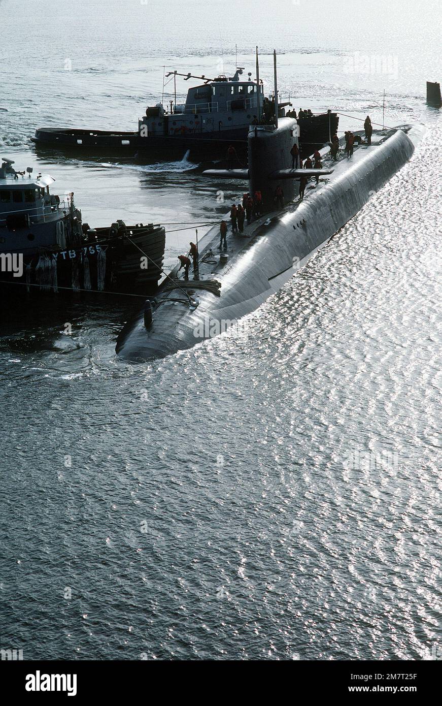 Two large harbor tugs, including USS OKMULGEE (YTB-765) , front ...