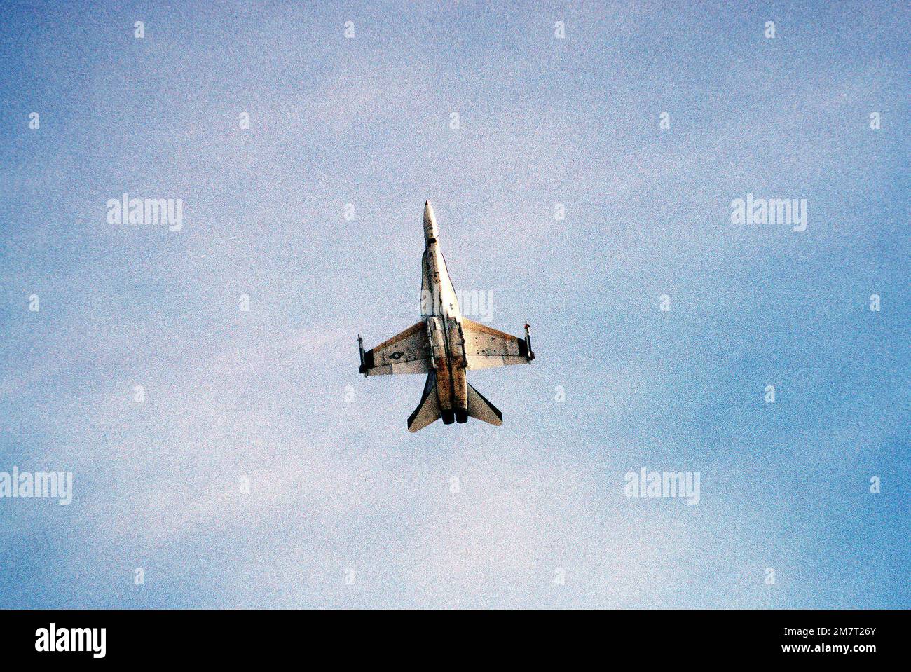 An underside view of an F-18 Hornet aircraft during flight ...