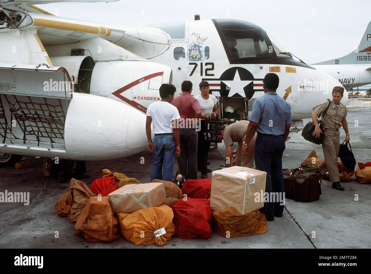 Flight and ground crewmen unload cargo from an S-3A Viking aircraft ...
